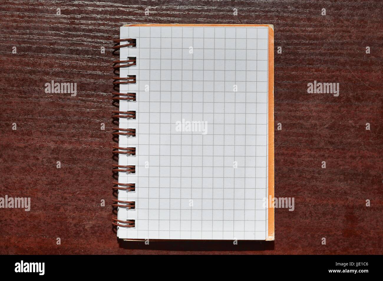 Notebook with square grid on a table Stock Photo - Alamy