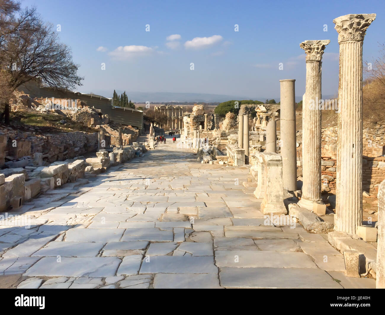 Roman stone pillars and statue ruins on road side in ephesus ...