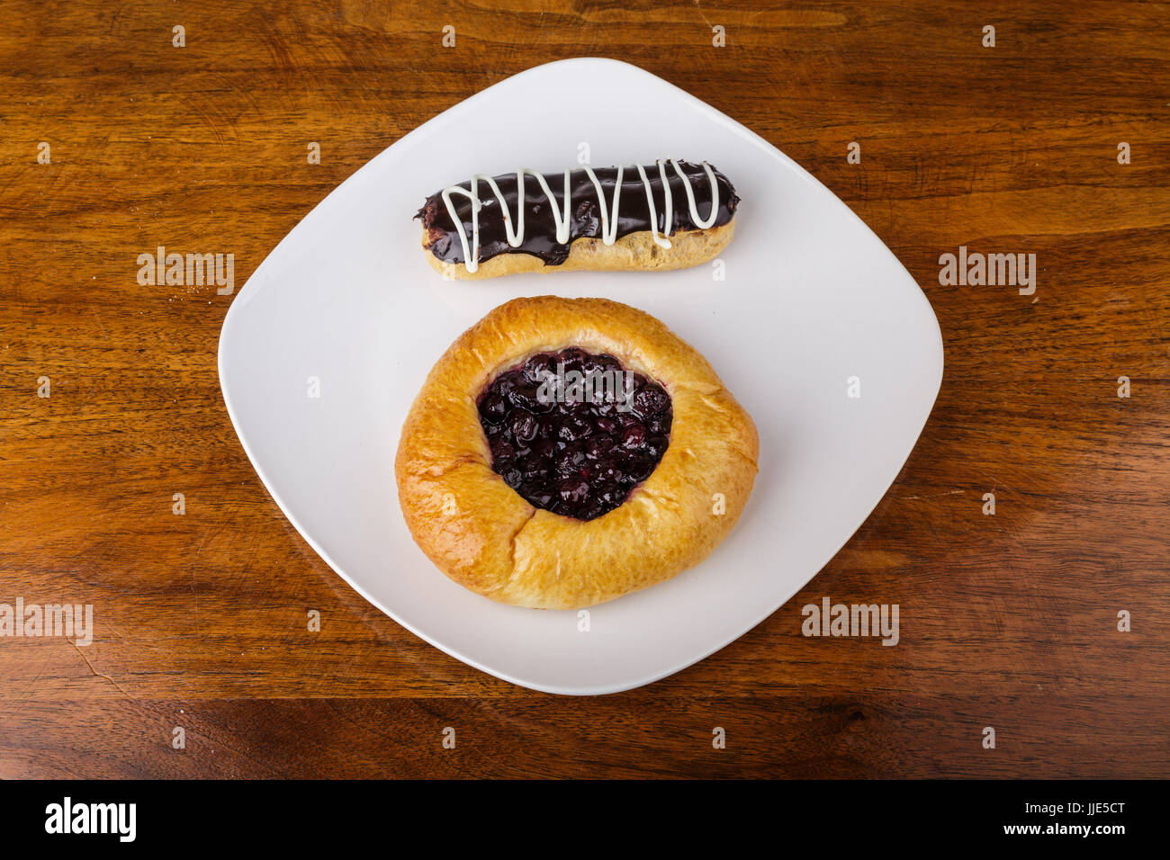 Two Pastries on Square Plate and Wood Table Stock Photo - Alamy