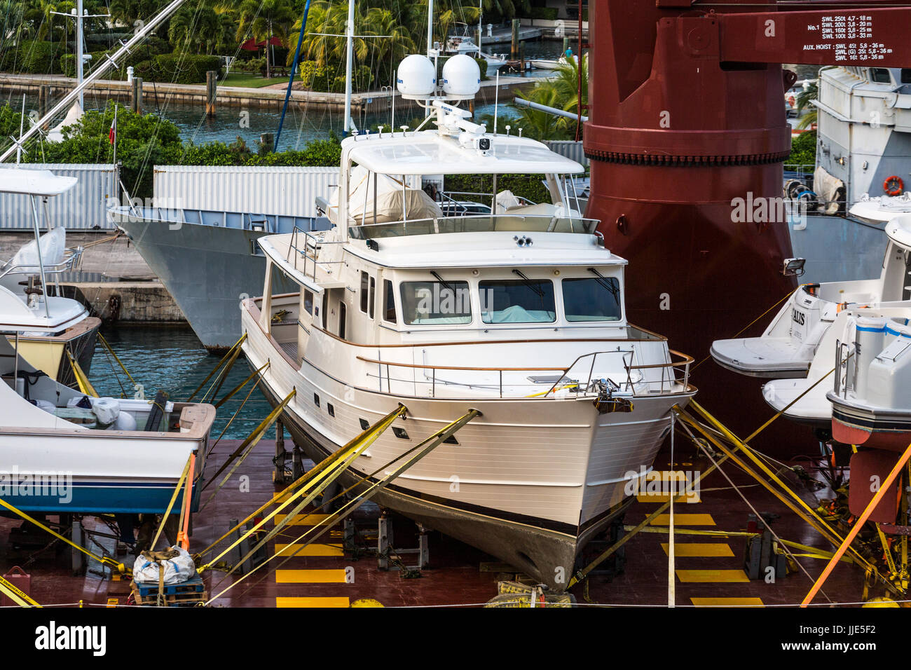 A ship delivering luxury yachts to a tropical harbor Stock Photo - Alamy