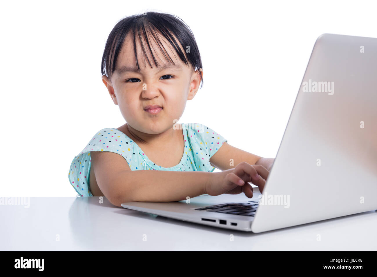 Asian Chinese little girl playing with laptop in isolated white ...