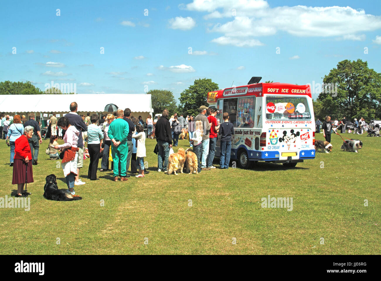 Dog show on a summer day people standing & queuing at ice cream van ...