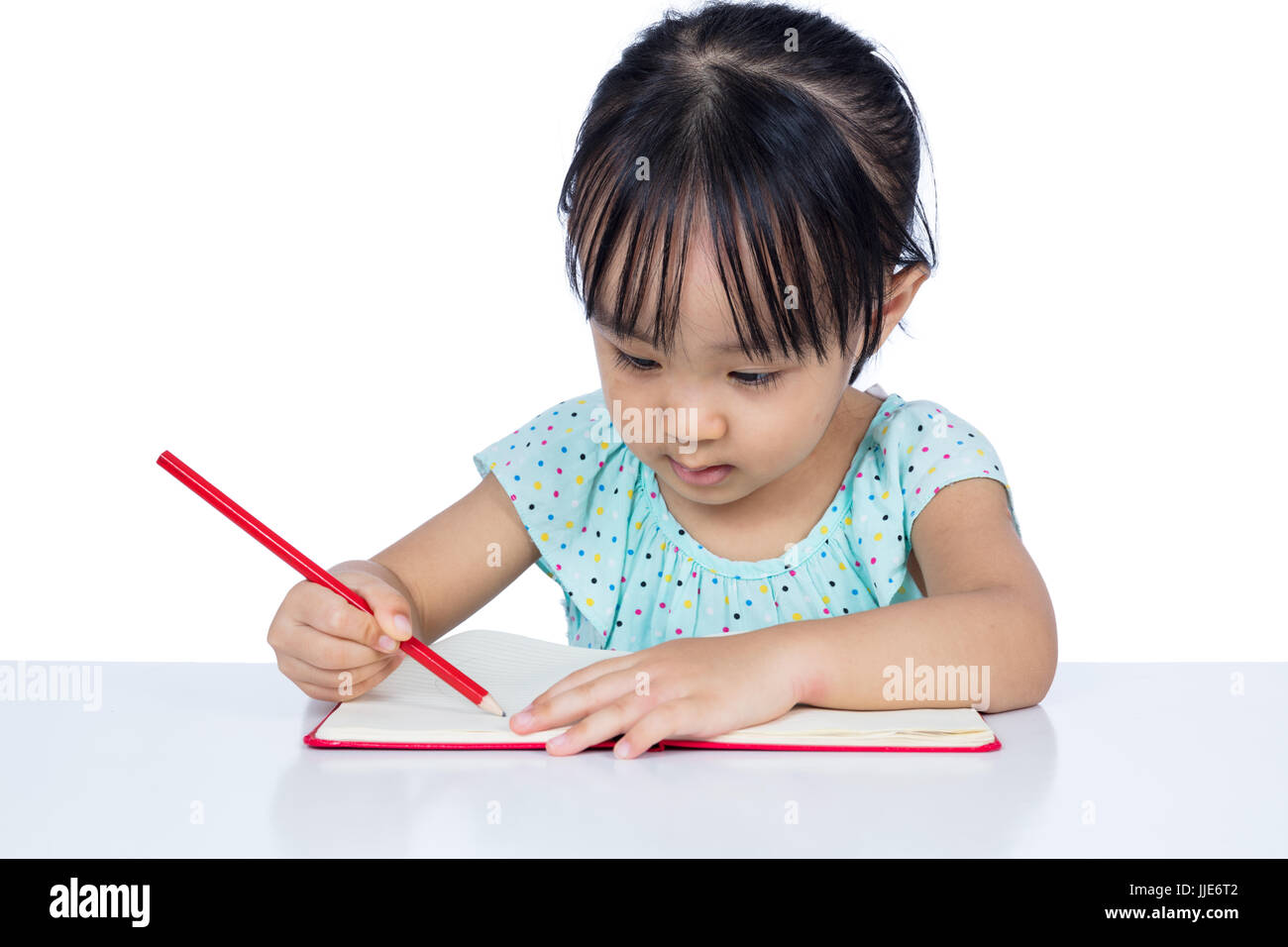 Asian Little Chinese girl writing on exercise book in isolated white ...