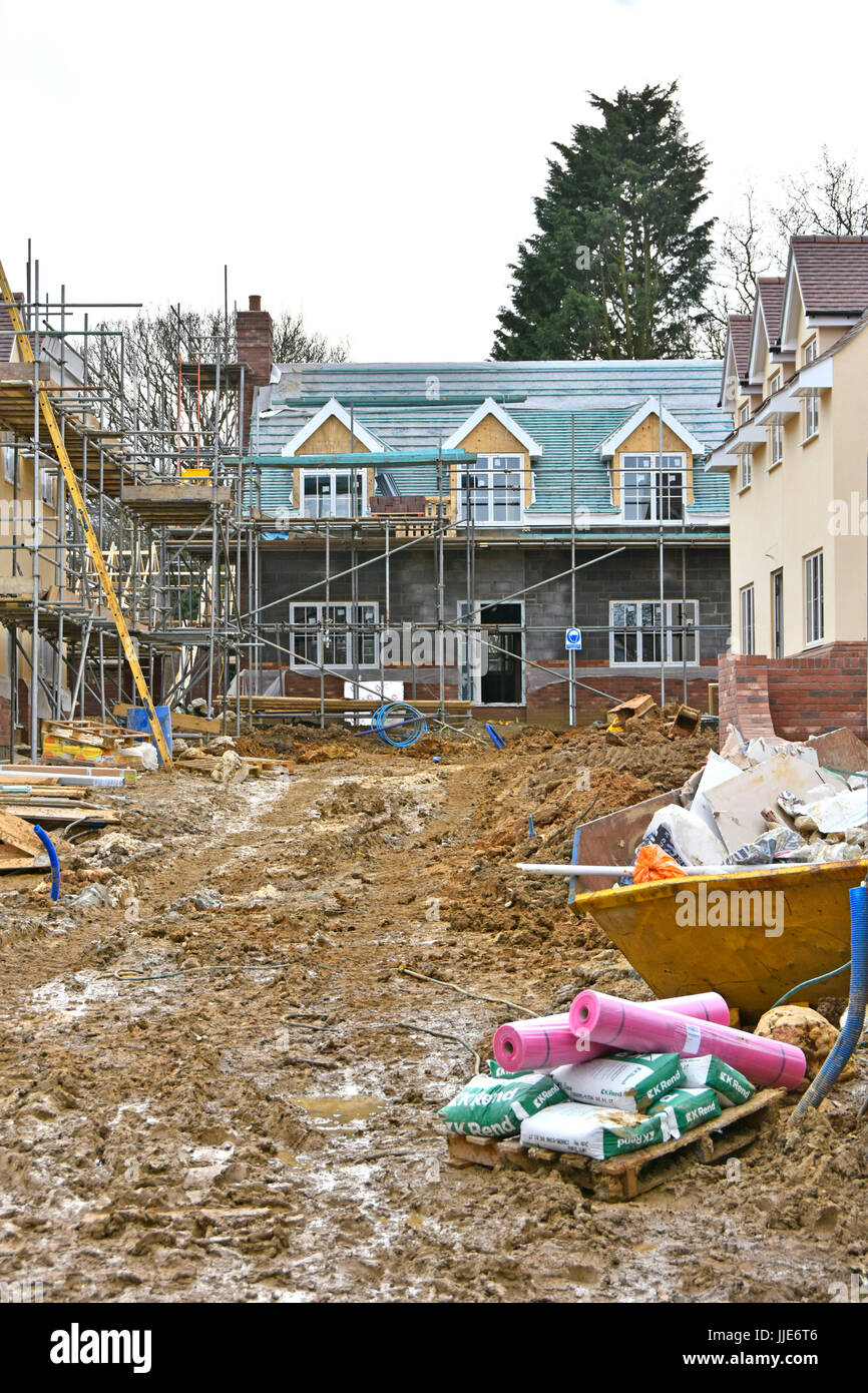 House & housing being erected in winter mud & clay on small congested ...