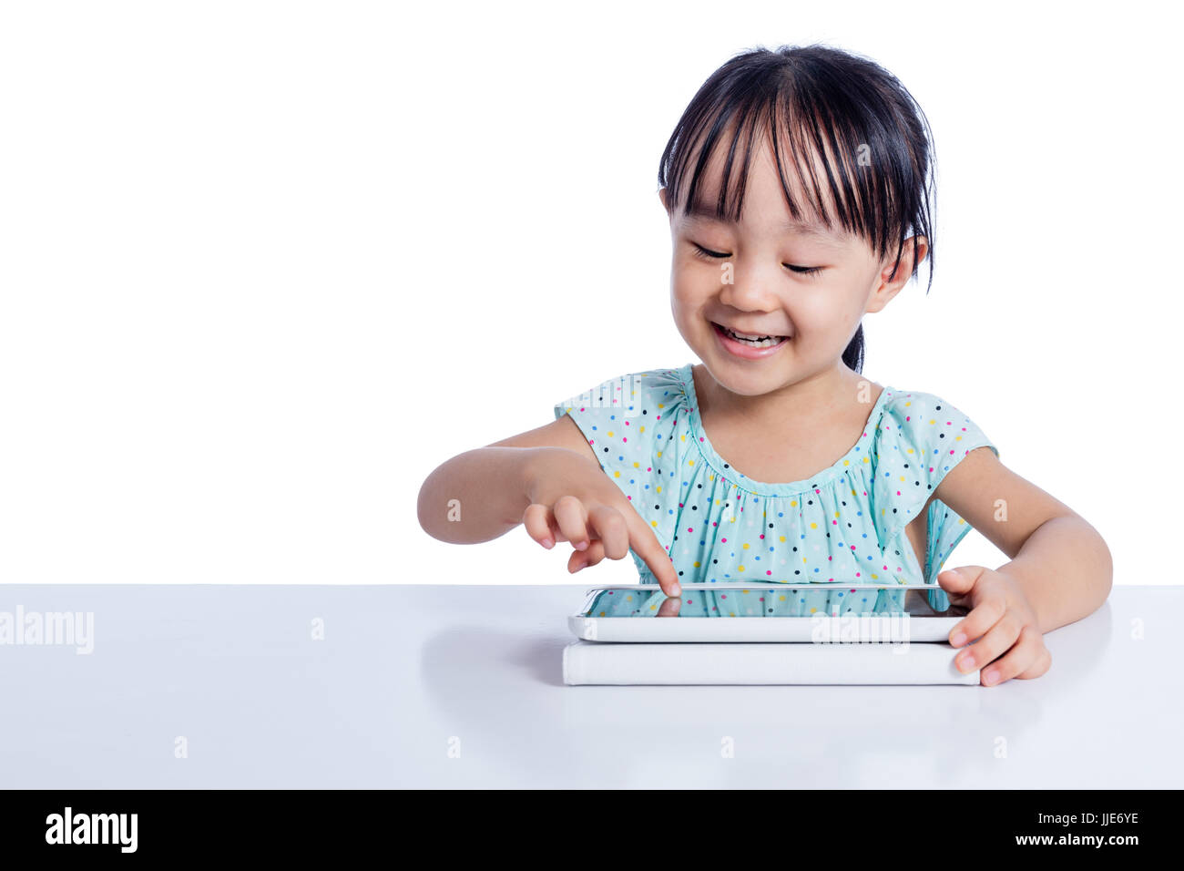 Asian Chinese little girl playing with tablet computer in isolated ...