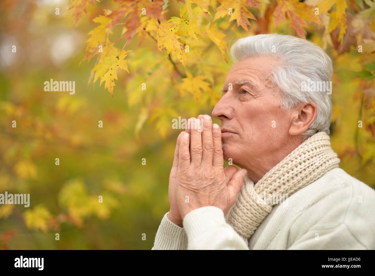 Thinking senior man praying Stock Photo - Alamy