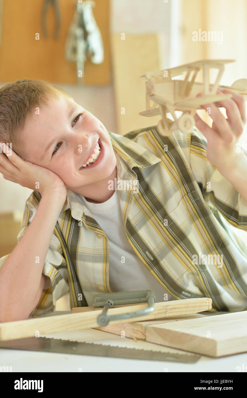 Cute boy sitting at table with model of ship Stock Photo - Alamy
