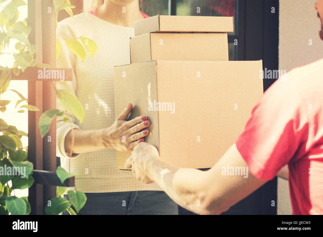 woman accepting a home delivery of boxes from delivery service courier ...