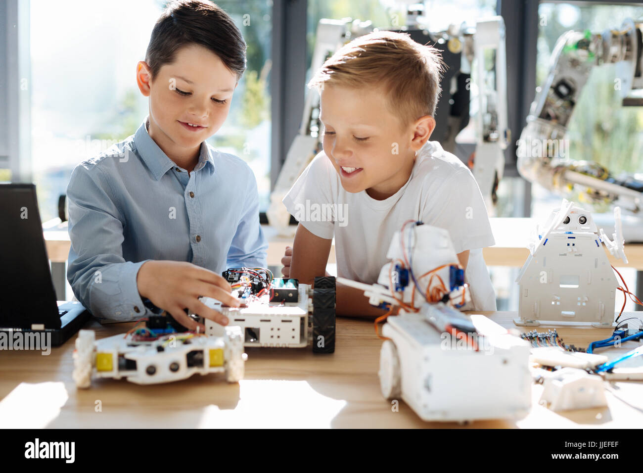 Pleasant little kids creating robots together Stock Photo - Alamy