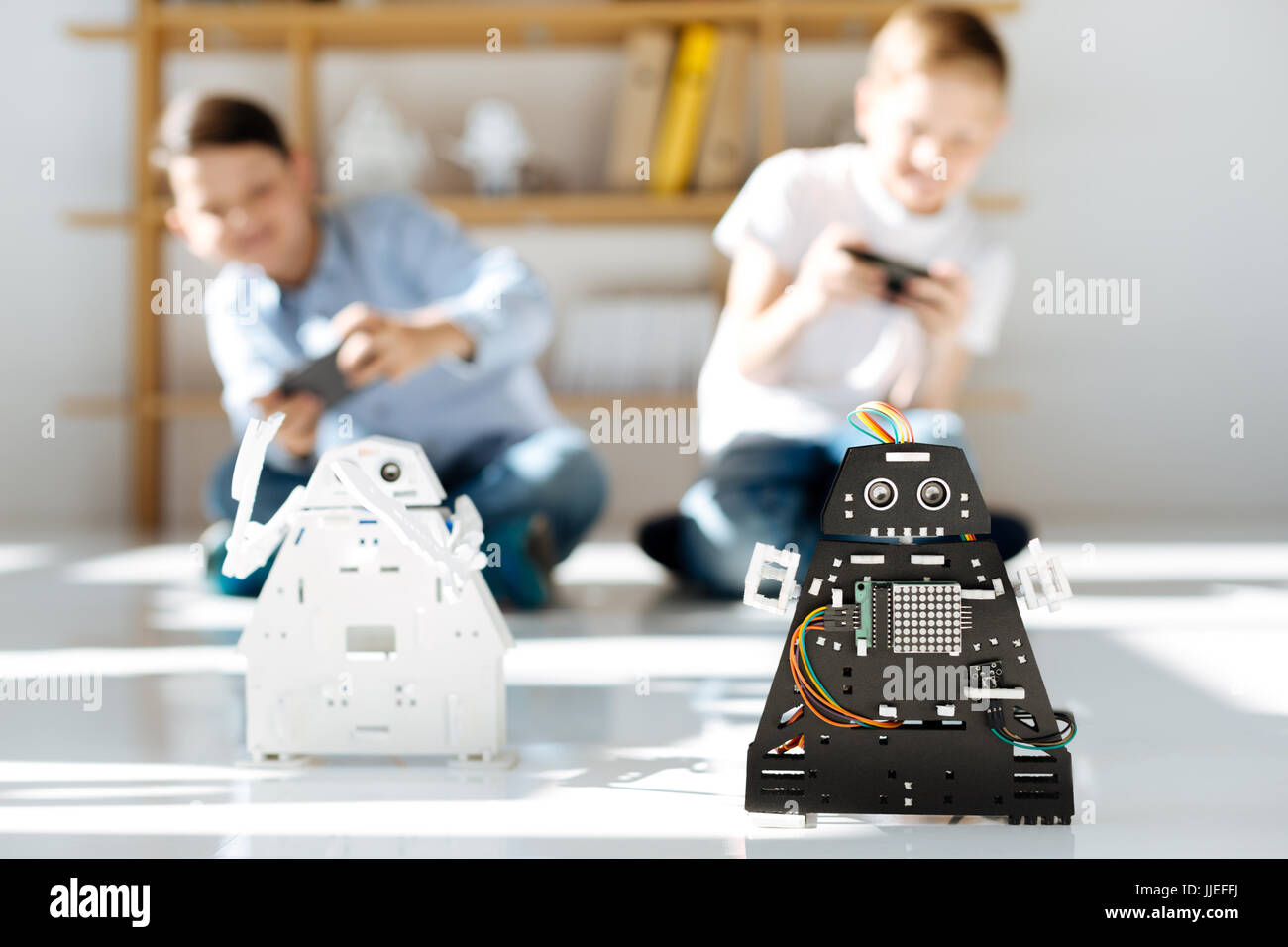 Two little friends conducting a robot race Stock Photo - Alamy
