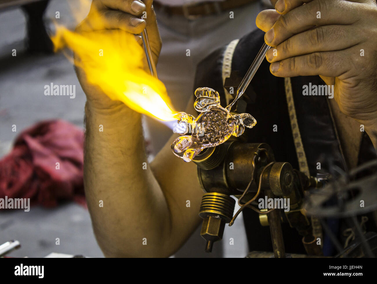 Artisan blowing glass in a traditional way, detail of craft and ...
