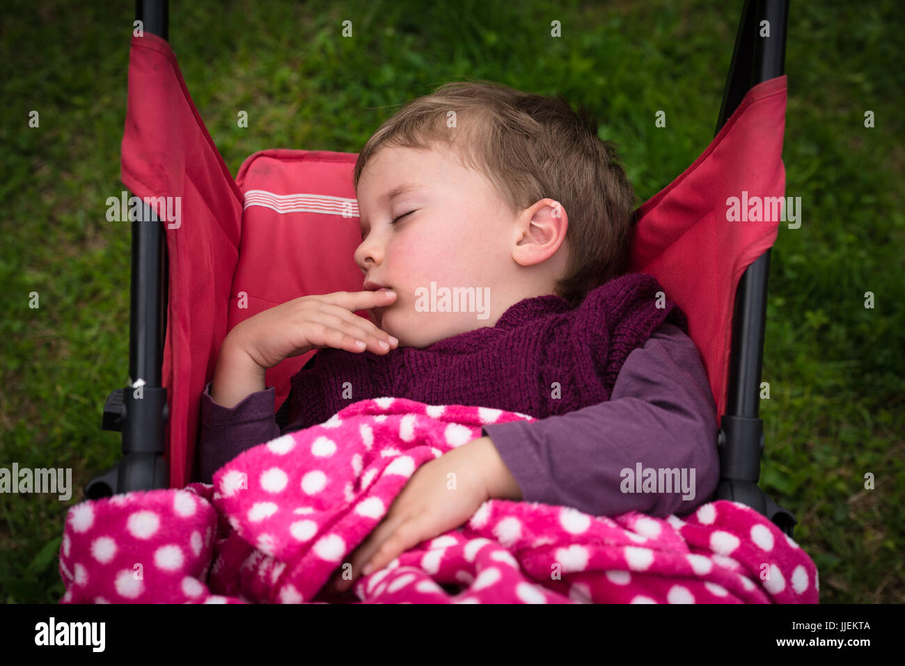 Cute child sleeping soundly in stroller Stock Photo - Alamy