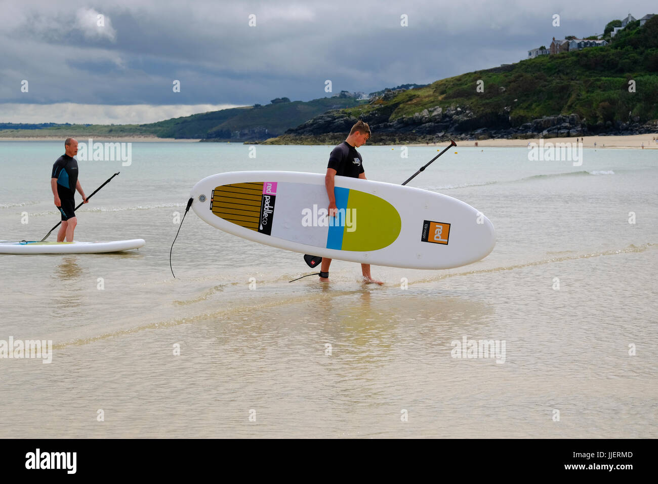 Man carrying paddleboard hi-res stock photography and images - Alamy
