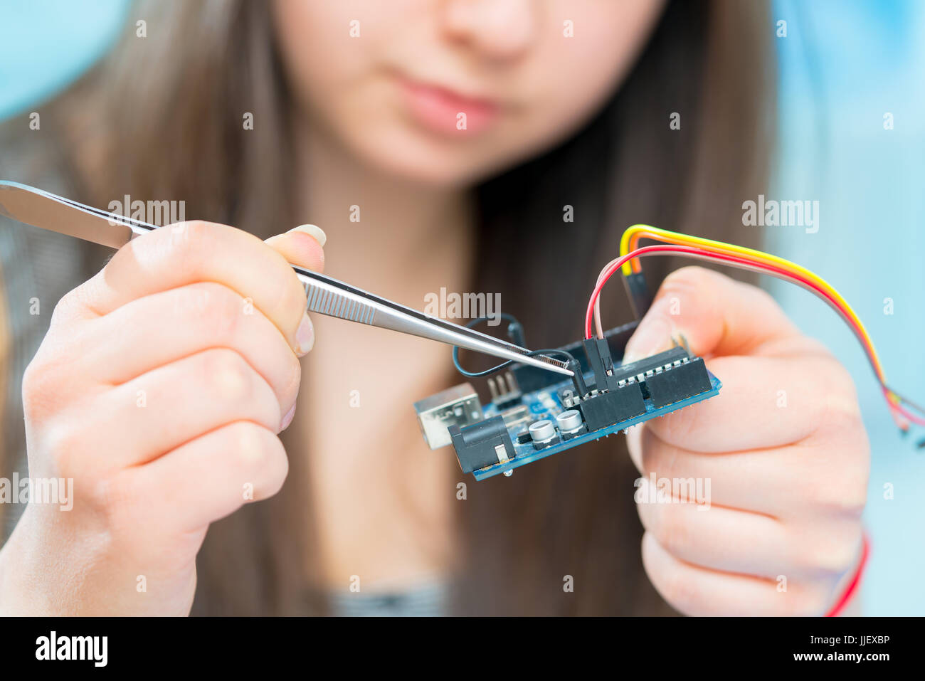 Student girl in electronics laboratory, experiment with microcontroller ...