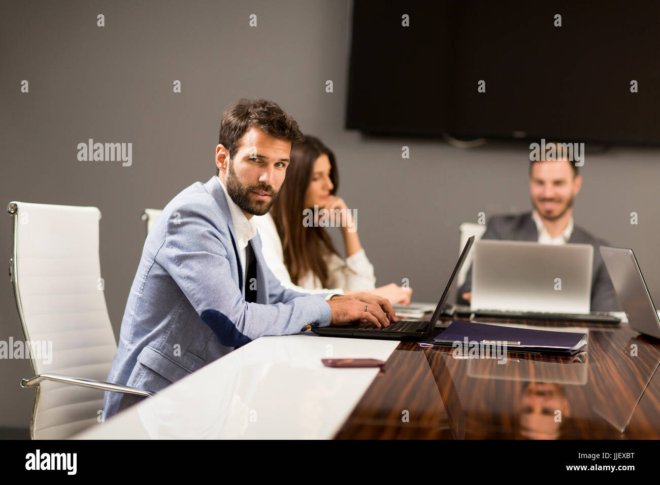 Young teamwork by the table in the office Stock Photo - Alamy
