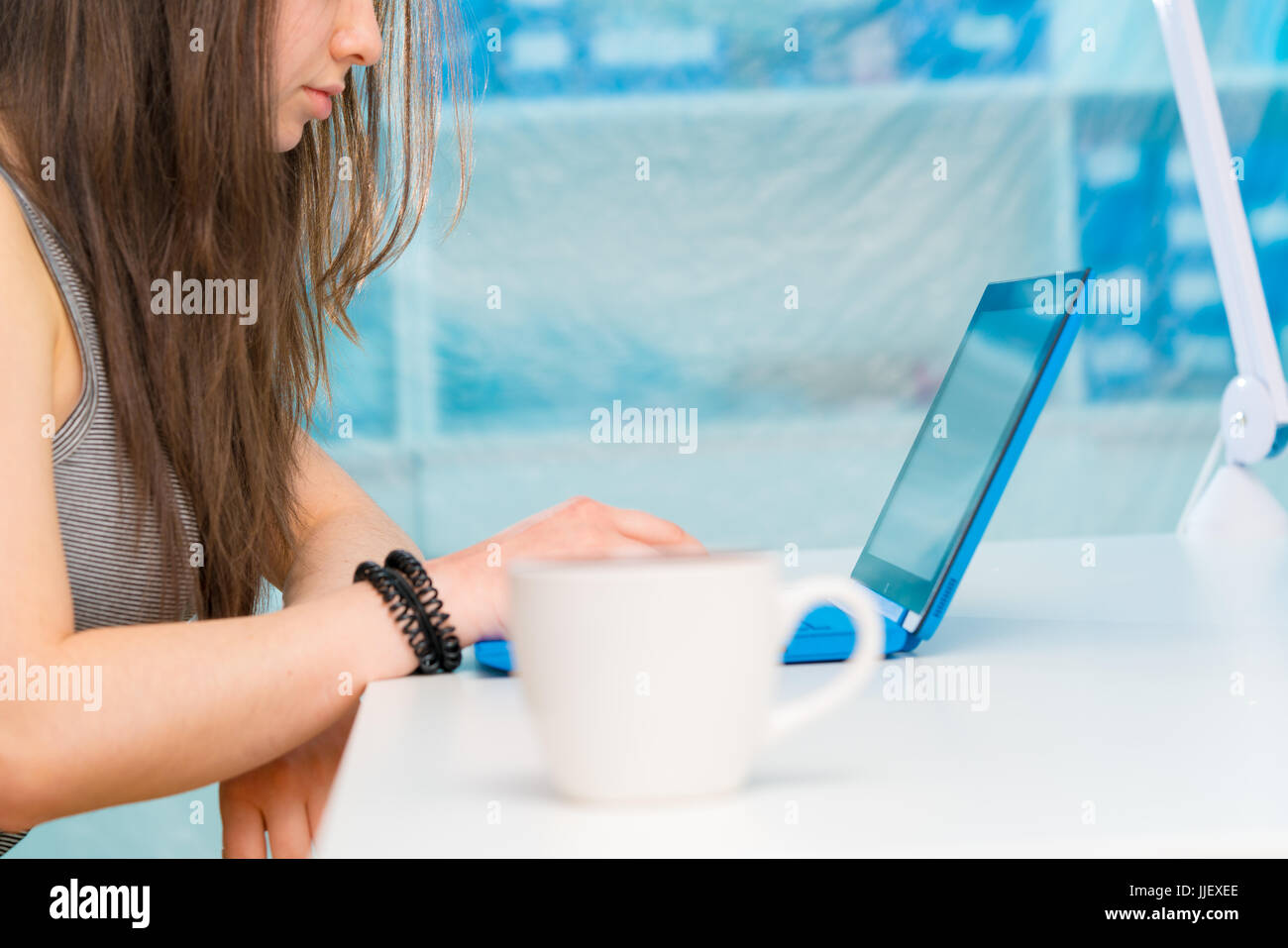 Girl using notebook and drink coffee Stock Photo - Alamy