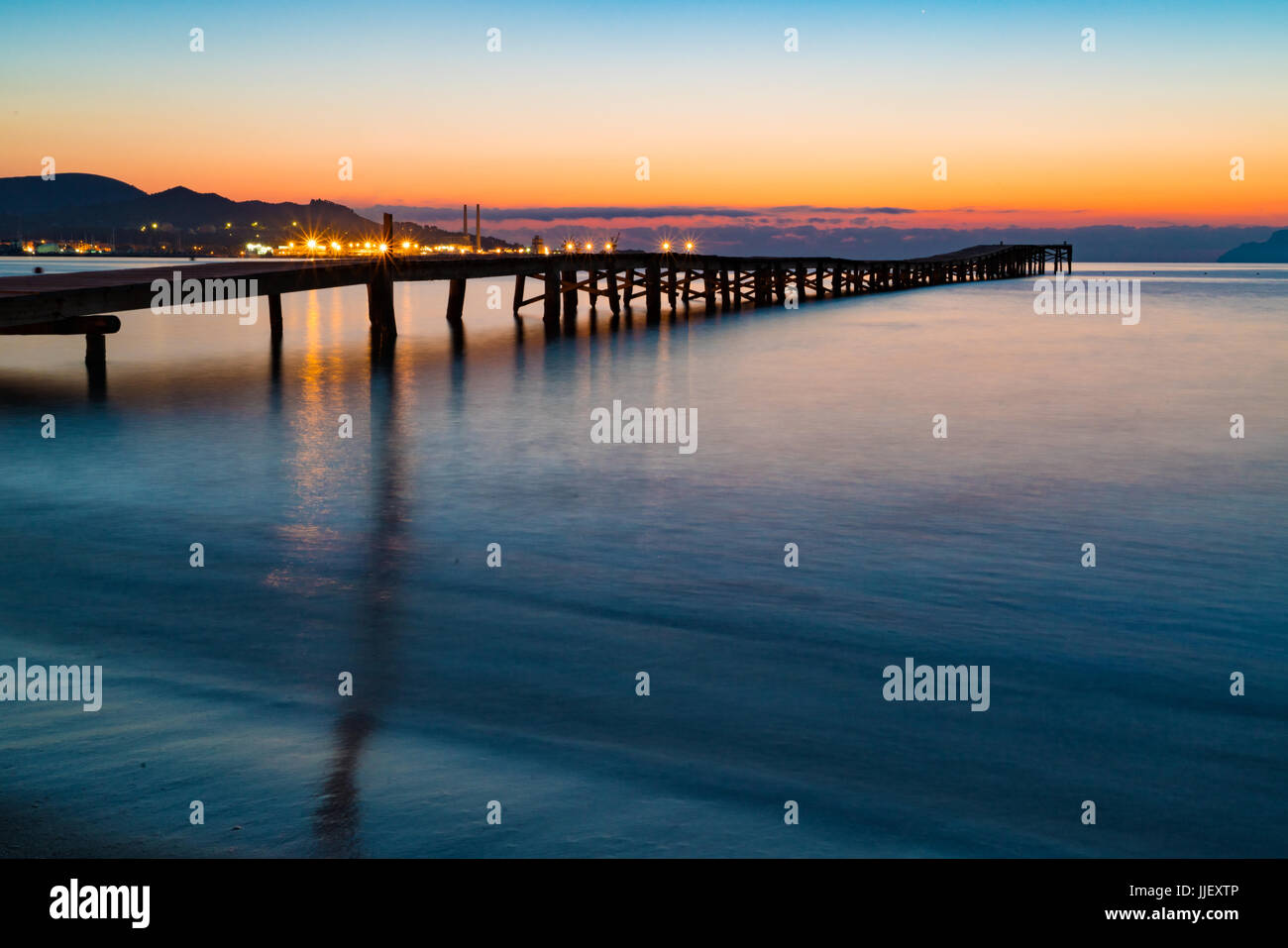 Sunset on a sandy beach and a wooden pier, Panorama Stock Photo - Alamy