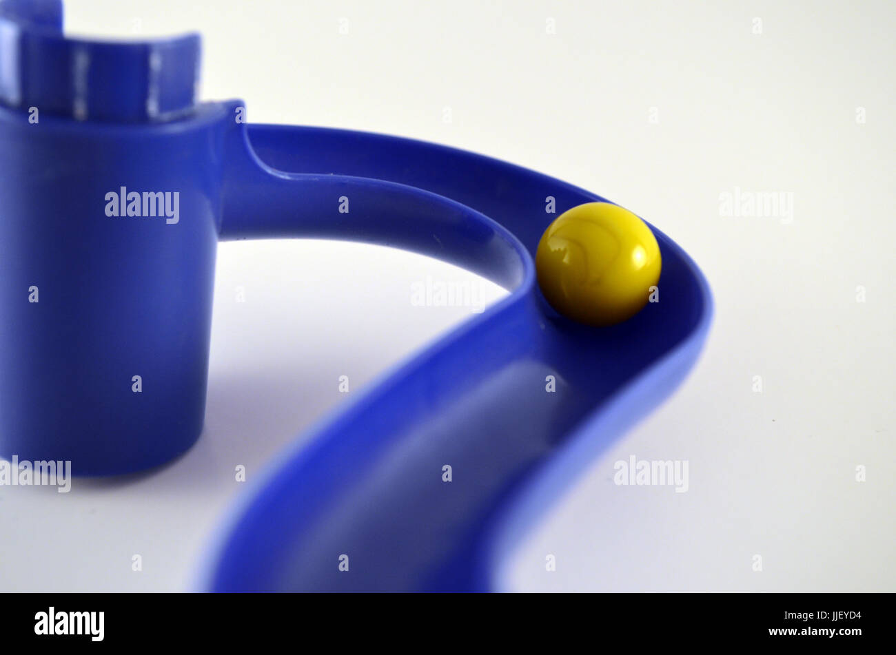 Yellow marble in blue marble track Stock Photo - Alamy