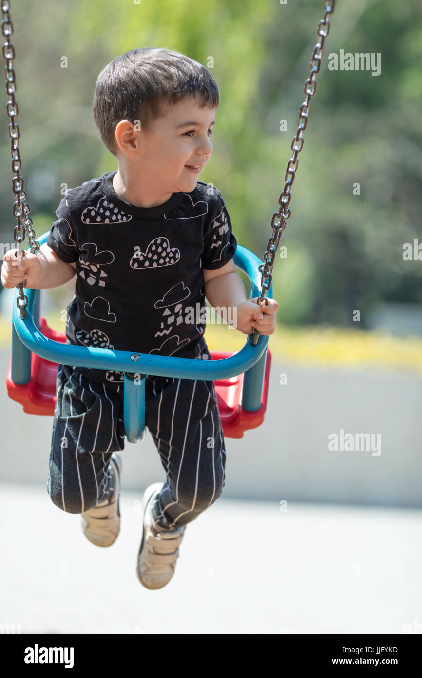 Smiling boy swinging in a swing Stock Photo - Alamy