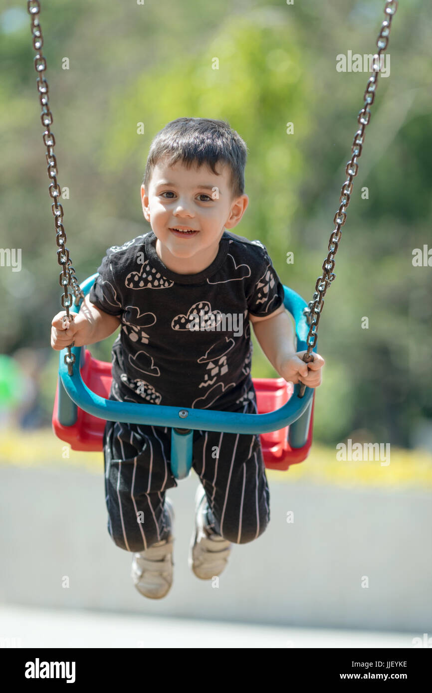 Smiling boy swinging in a swing Stock Photo - Alamy