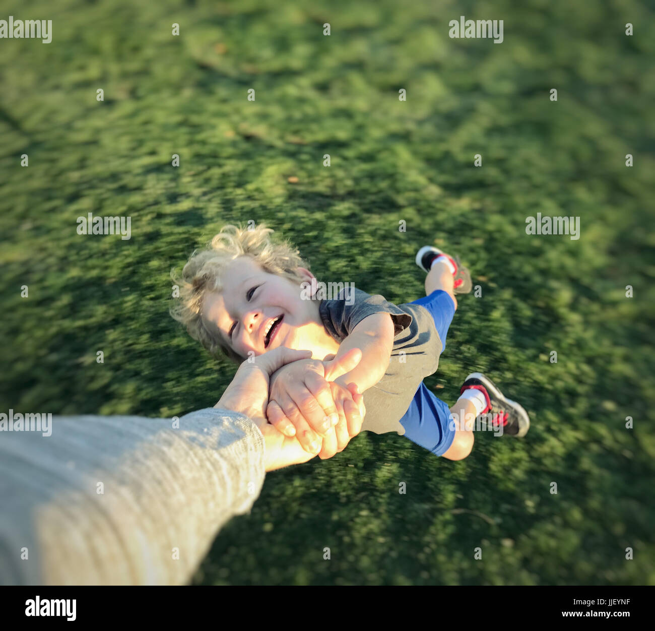 Man spinning his son around Stock Photo - Alamy
