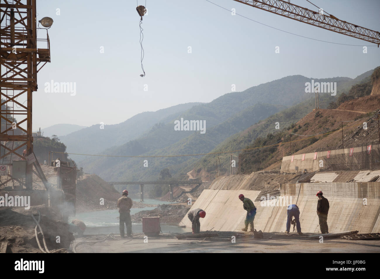 Construction workers below crane at dam above nam ou river hi-res stock ...