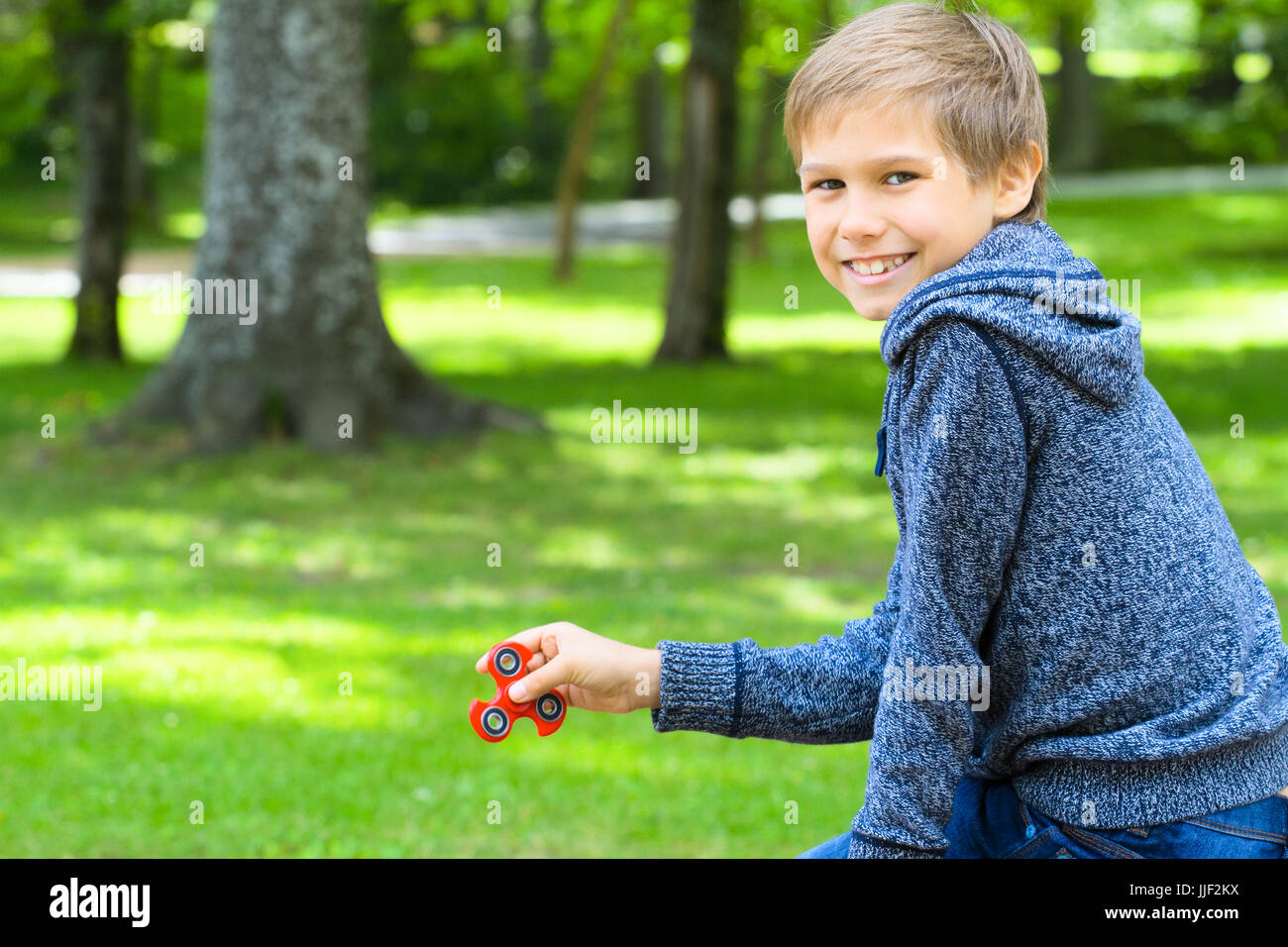 Boy with a fidget spinner outdoors Stock Photo - Alamy