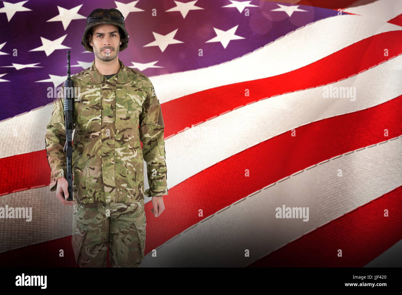 Full length portrait of soldier with rifle against waving flag of ...