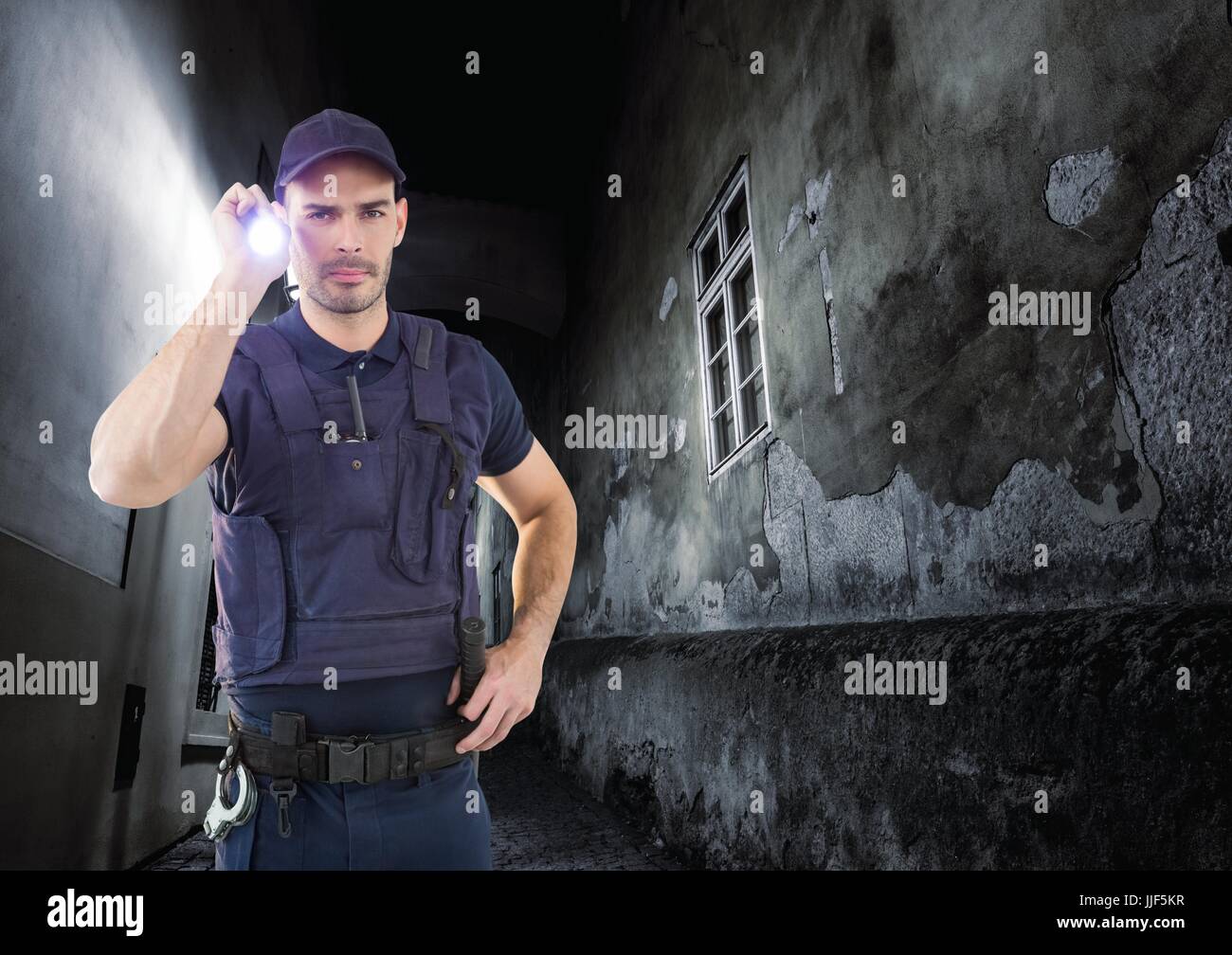 Digital composite of security guard in a alley at night with torch ...
