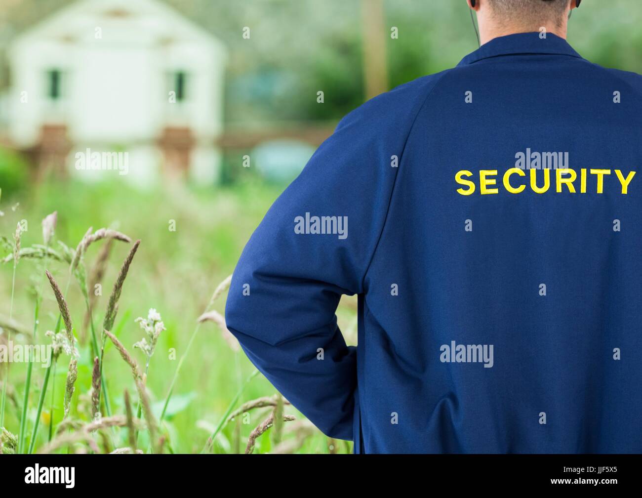 Digital composite of Rear view of security guard standing on field ...