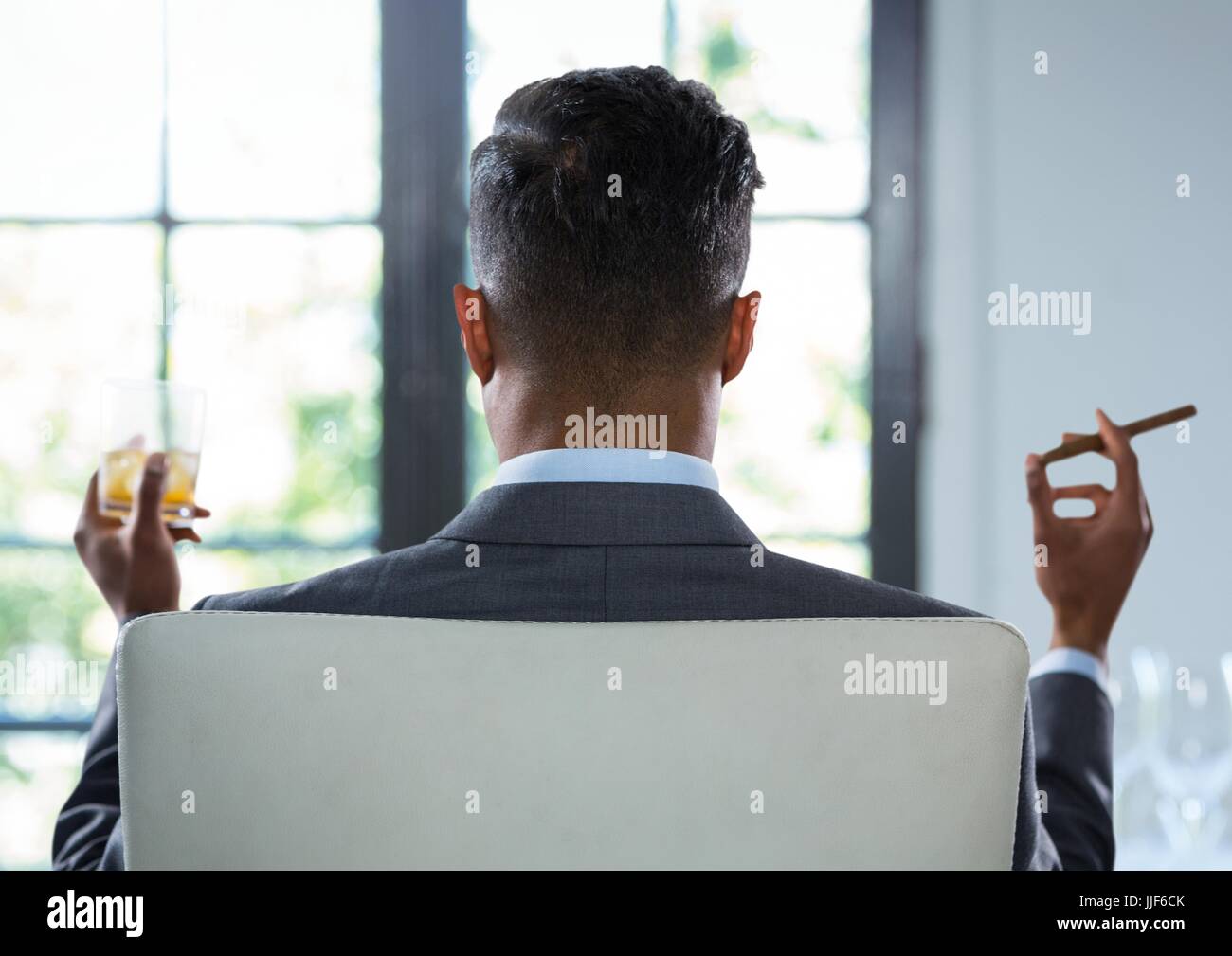 Digital composite of Businessman Back Sitting in Chair with cigar and ...
