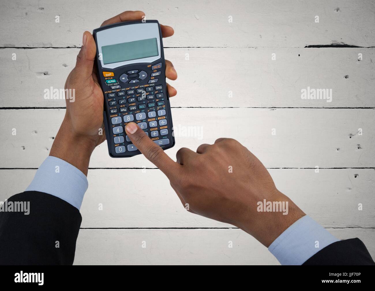 Digital composite of Hands with calculator against white wood panel ...