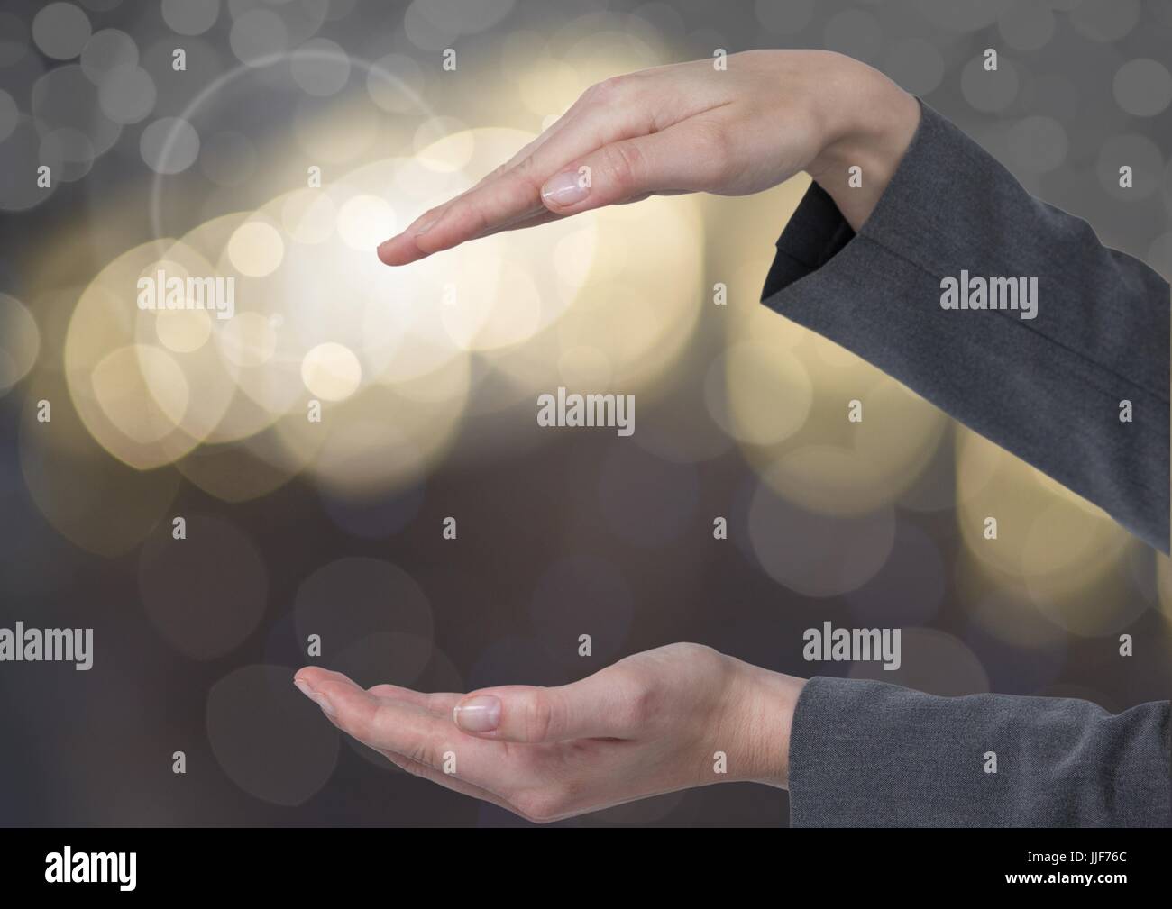 Digital composite of Hands holding invisible space with sparkling light ...