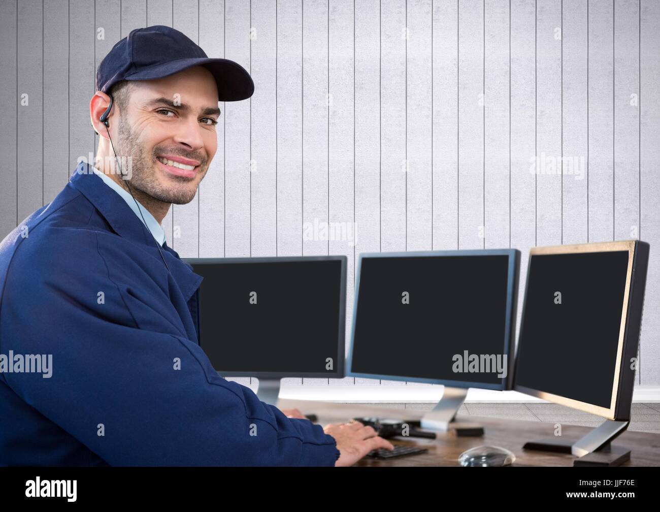 Digital composite of security guard smiling in front of the computers ...