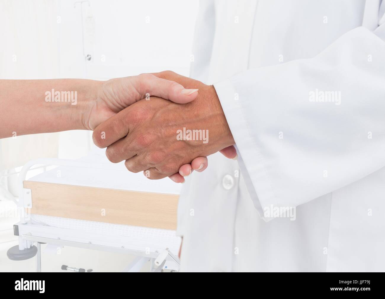 Digital composite of doctor and patient handshake in the hospital Stock ...