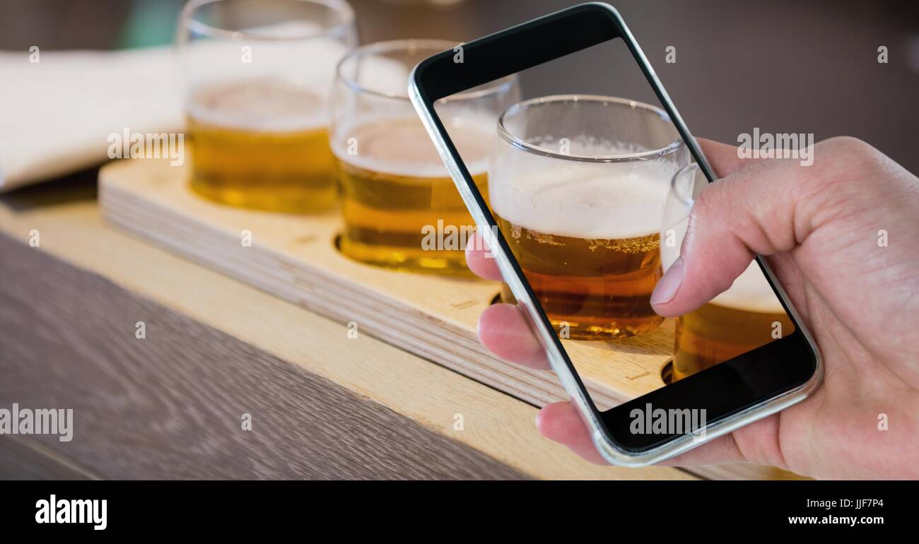 Digital composite of Hand photographing beer glasses through smart ...