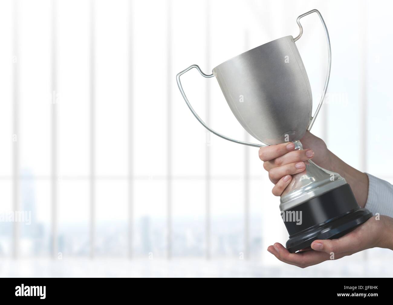 Digital composite of Business hand holding trophy against window Stock ...