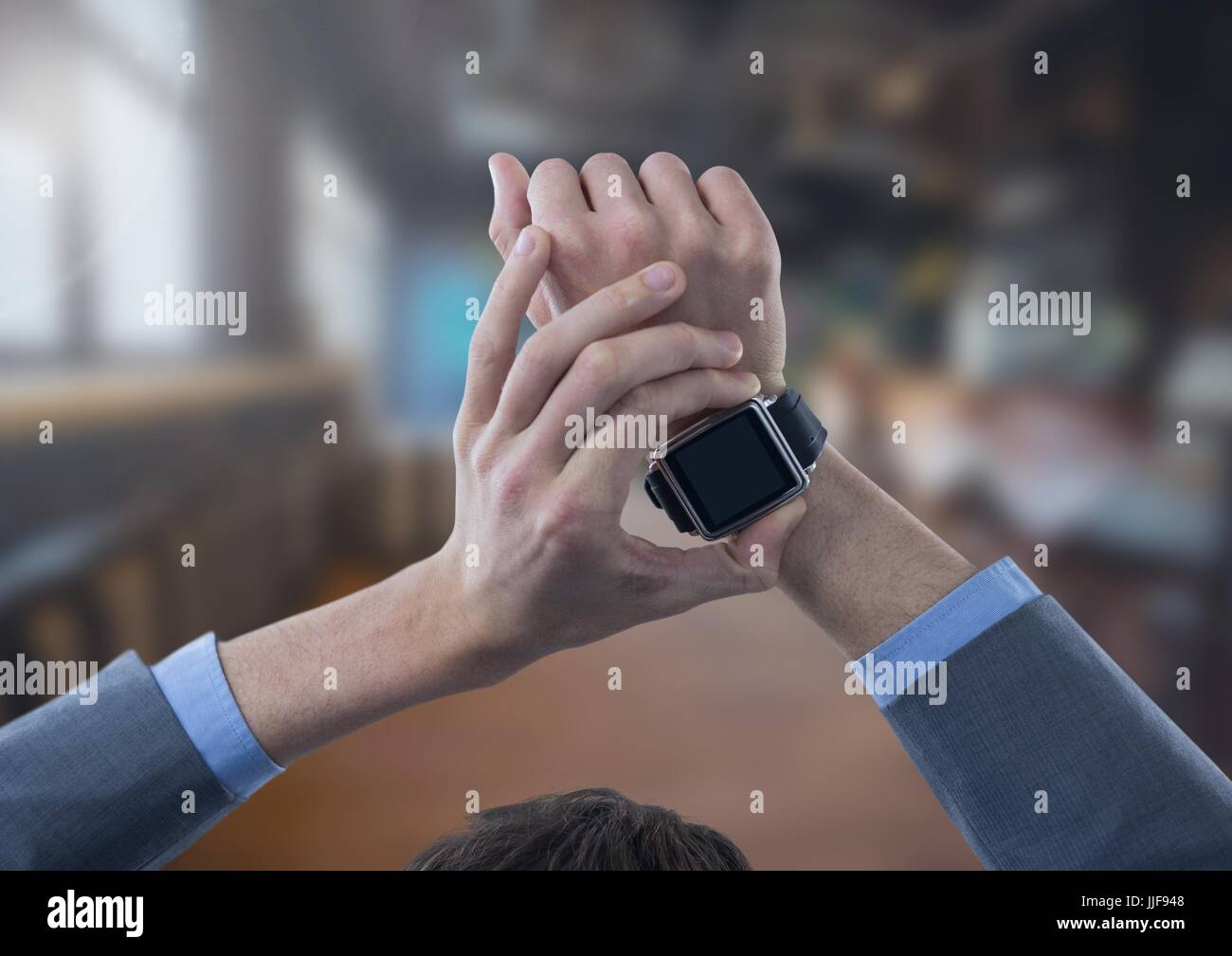 Digital composite of Businessman holding watch in large room Stock ...