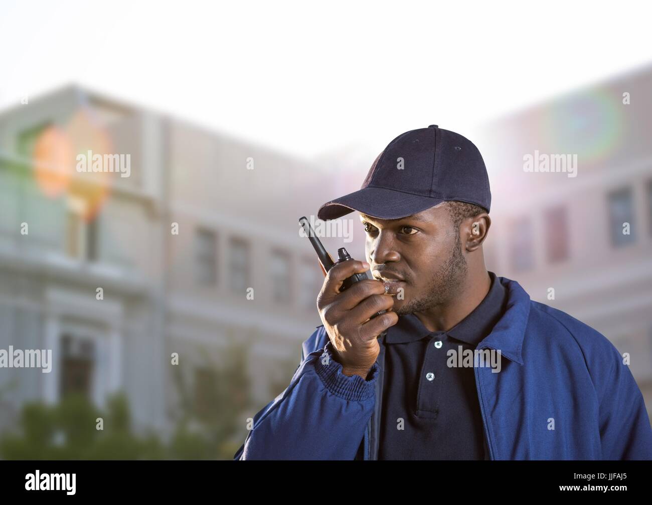 Digital composite of security guard speaking with the walkie-talkie in ...