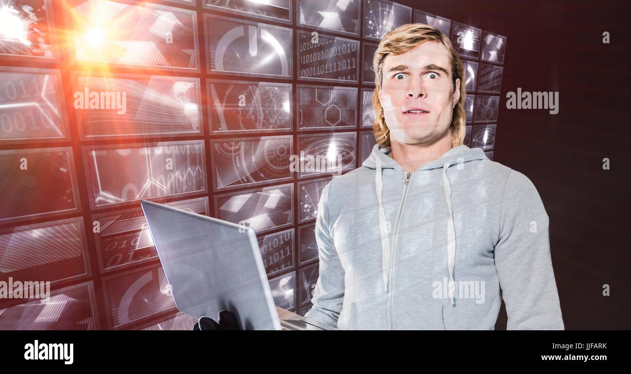 Digital composite of Hacker holding laptop standing by digital screen ...
