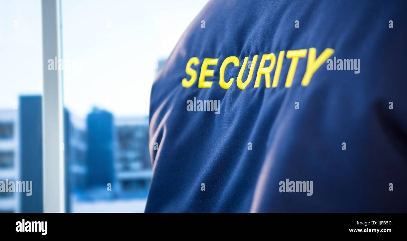 Digital composite of Back of security guard jacket against blurry ...