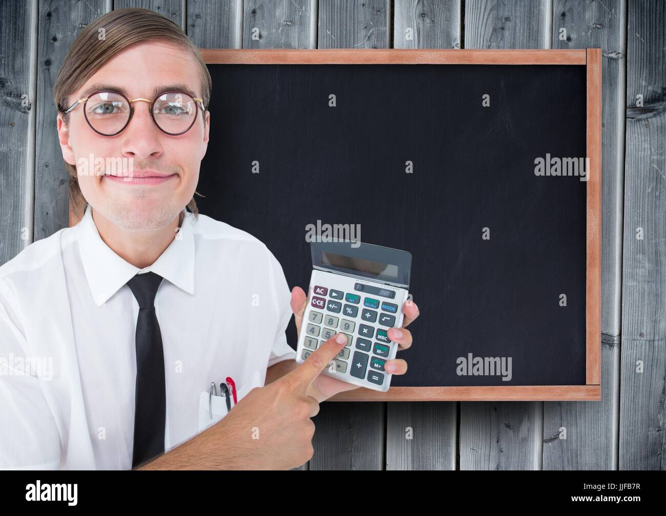 Digital composite of Man looking up with calculator against chalkboard ...