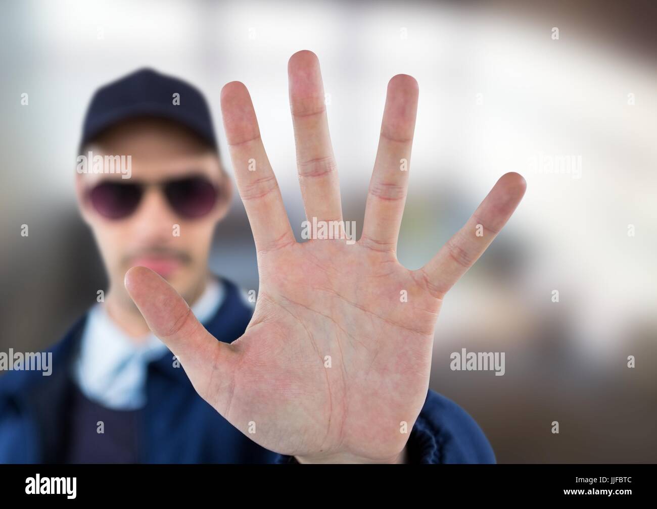 Digital composite of security guard whit his hand up saying stop Stock ...