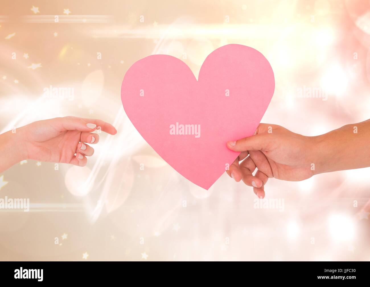 Digital composite of Hands with heart and sparkling light bokeh ...