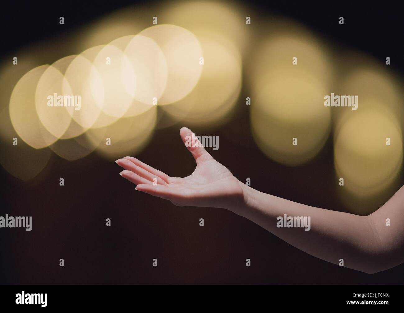 Digital composite of Hand reaching asking in wonder with sparkling ...
