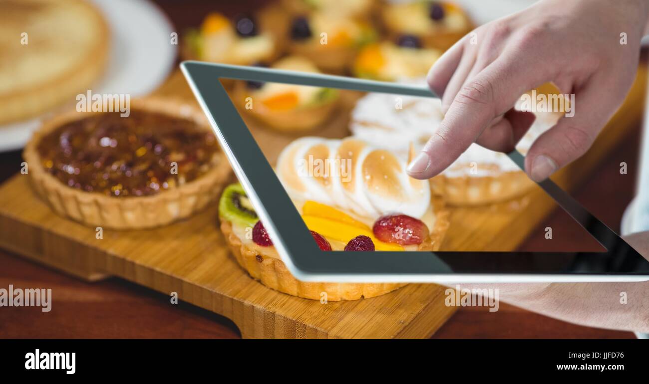 Digital composite of Hand photographing tarts through digital tablet at ...
