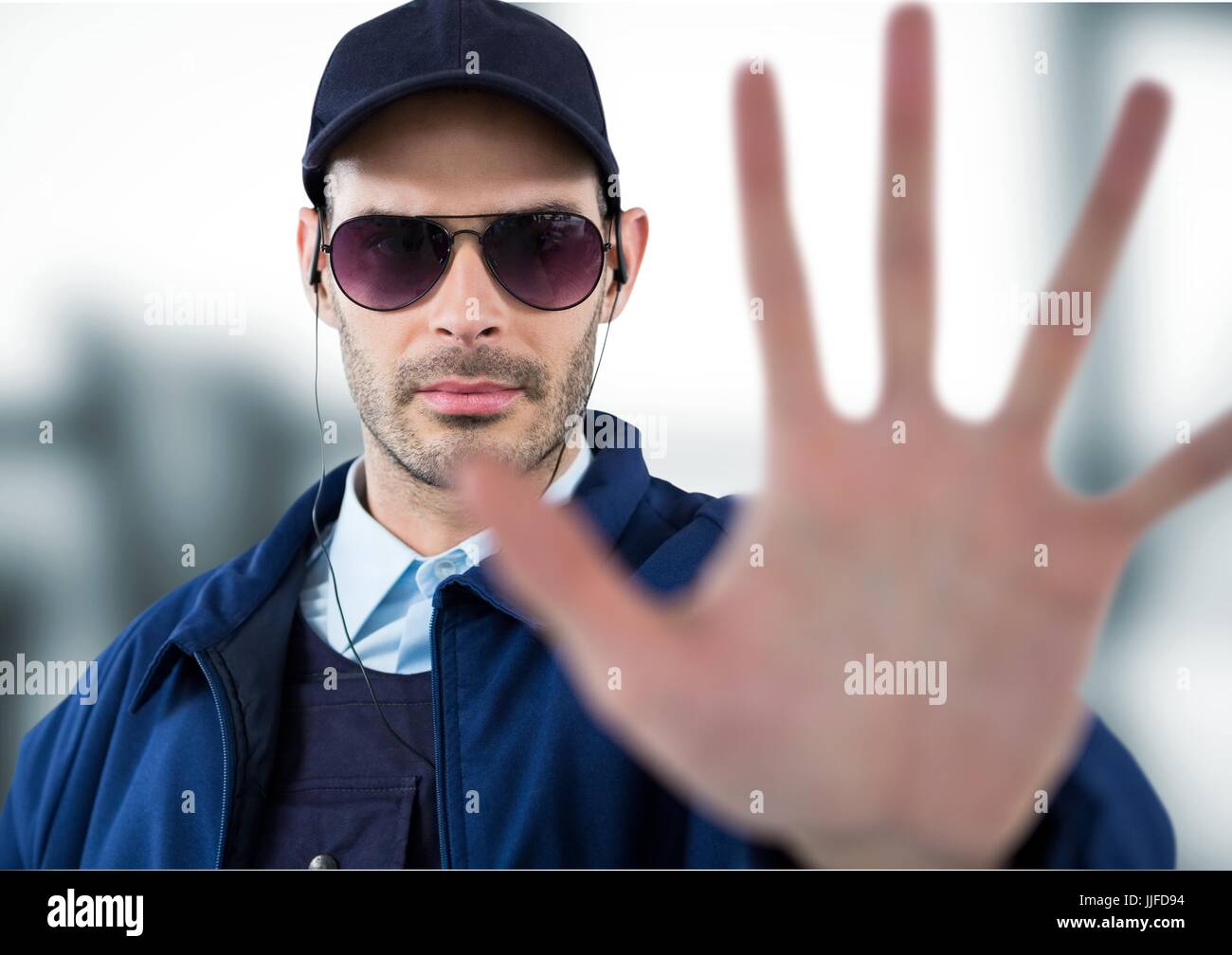 Digital composite of security guard with headphones saying stop with ...