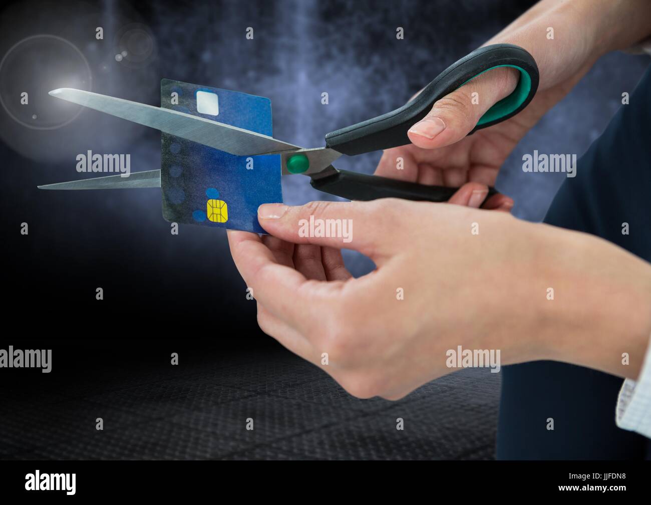 Digital composite of Hands cutting bank card with dark background Stock ...
