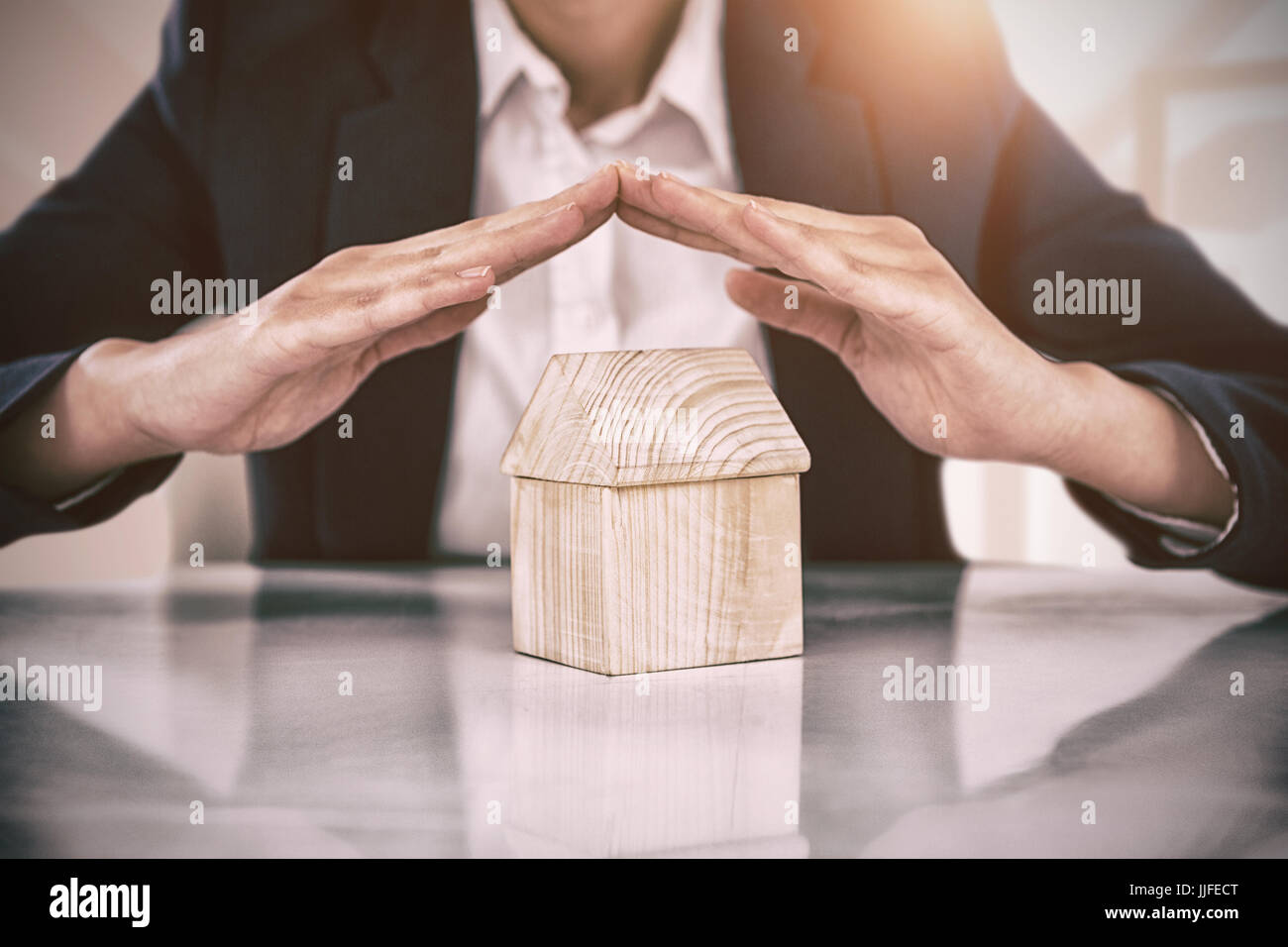 insurer protecting a house by his hands against white room with opened ...