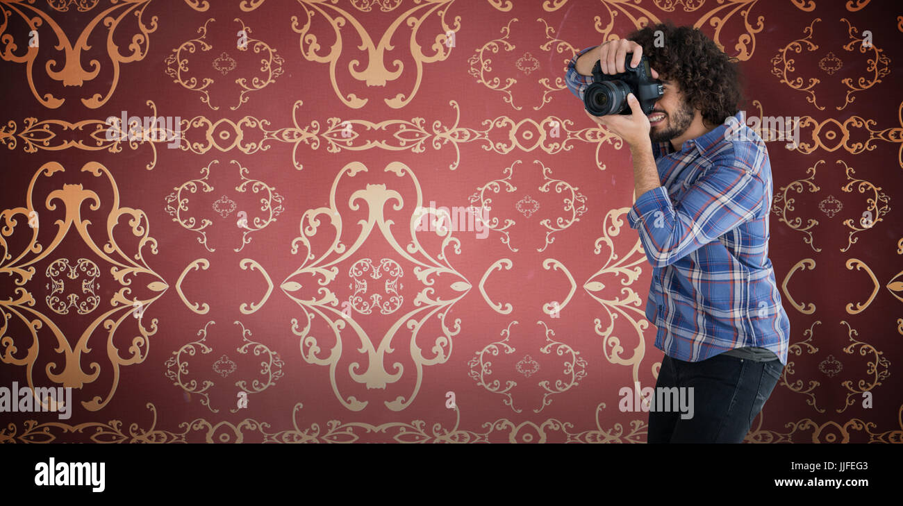 Male photographer photographing through camera against room with ...